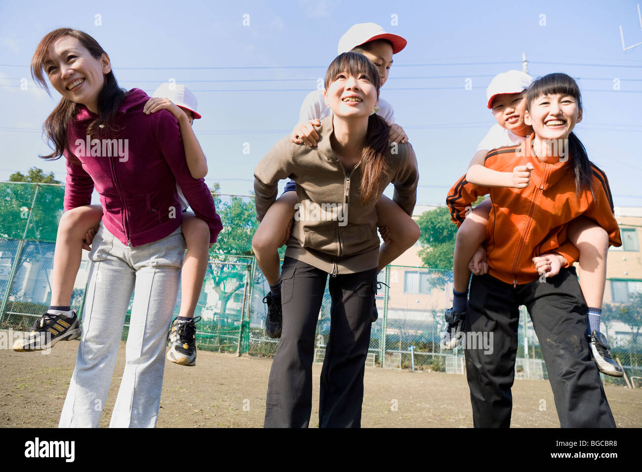 Three mothers carrying children on their back Stock Photo - Alamy