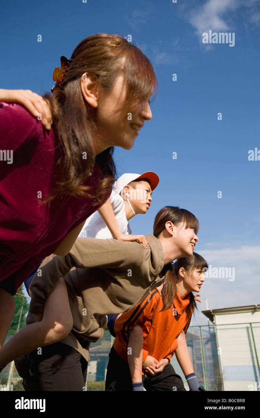 Three mothers carrying children on their back Stock Photo - Alamy