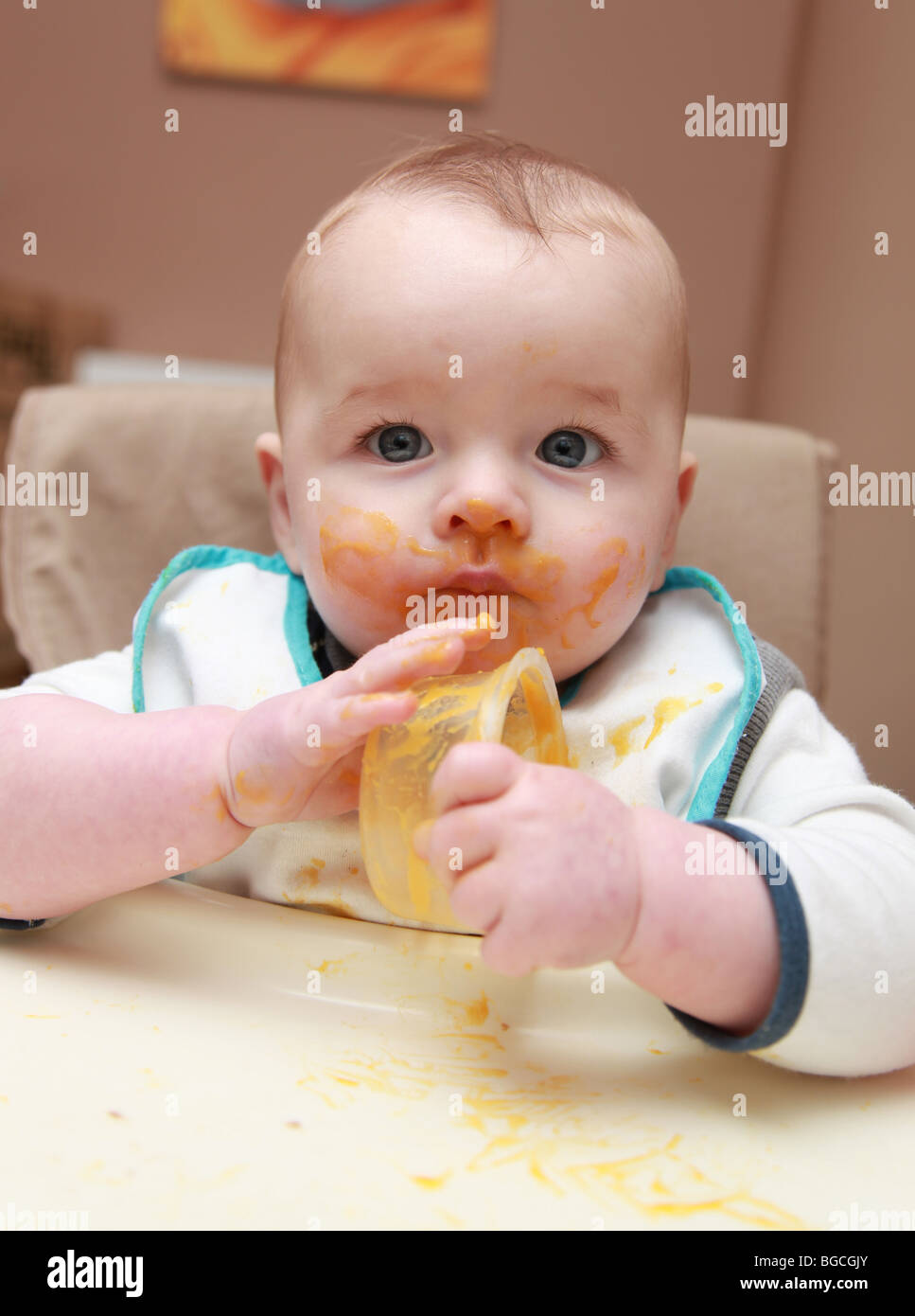 Baby boy feeding himself Stock Photo - Alamy