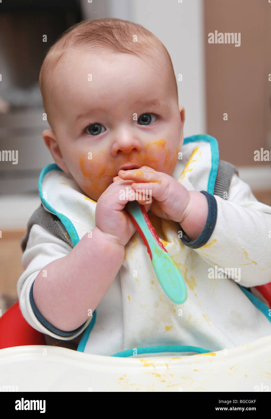 Baby boy feeding himself Stock Photo - Alamy