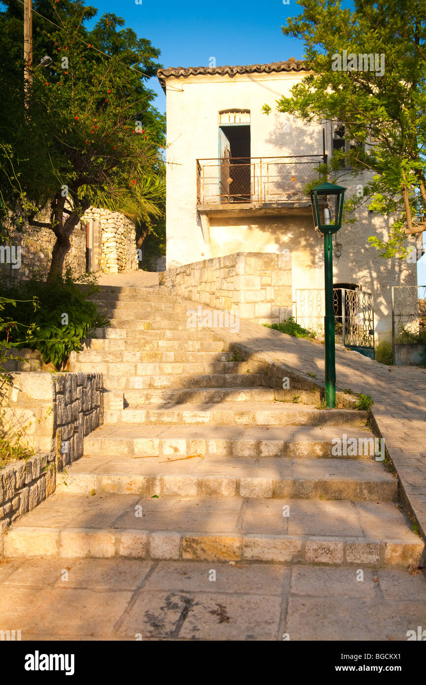 Well kept stone steps lead up and through a lane in a Greek village. A ...