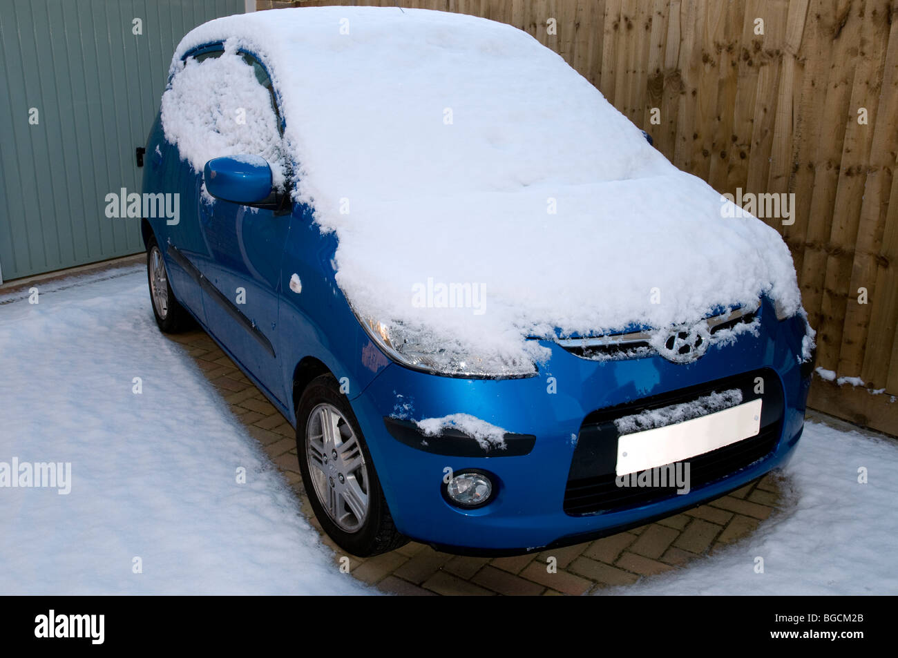 A small blue car covered in snow in December 2009 Stock Photo - Alamy