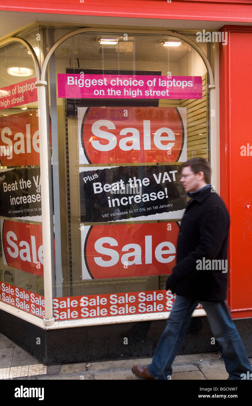 A man walks past a shop window advertising its sale. A poster ...