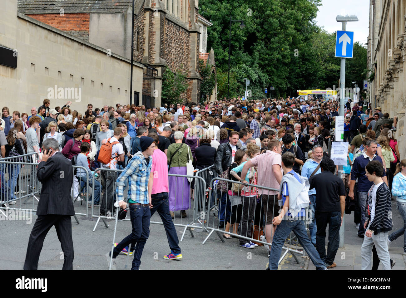 Crowd on street queuing, contained with barricades, UK Stock Photo - Alamy