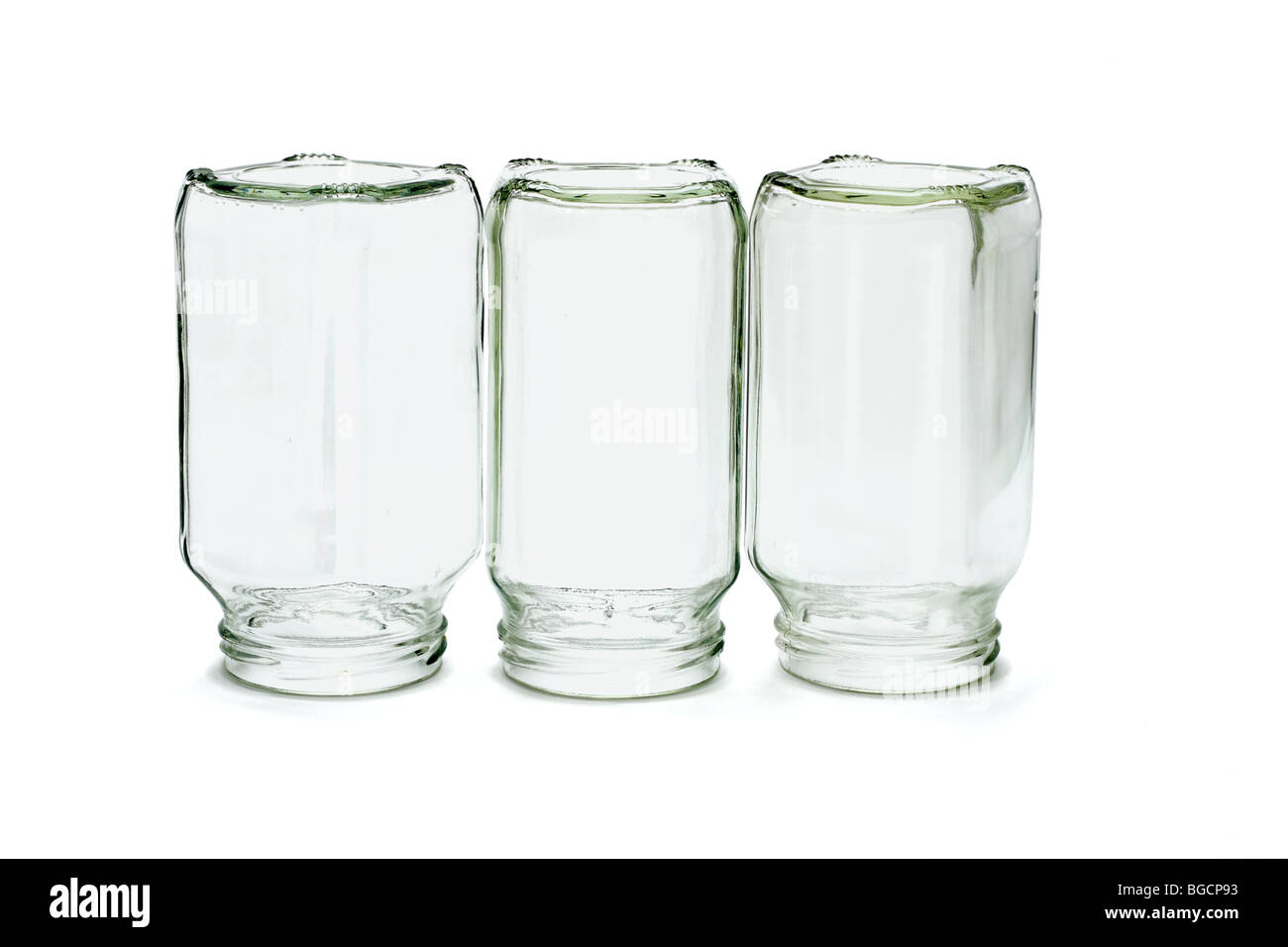 Three glass bottles inverted on white background Stock Photo - Alamy