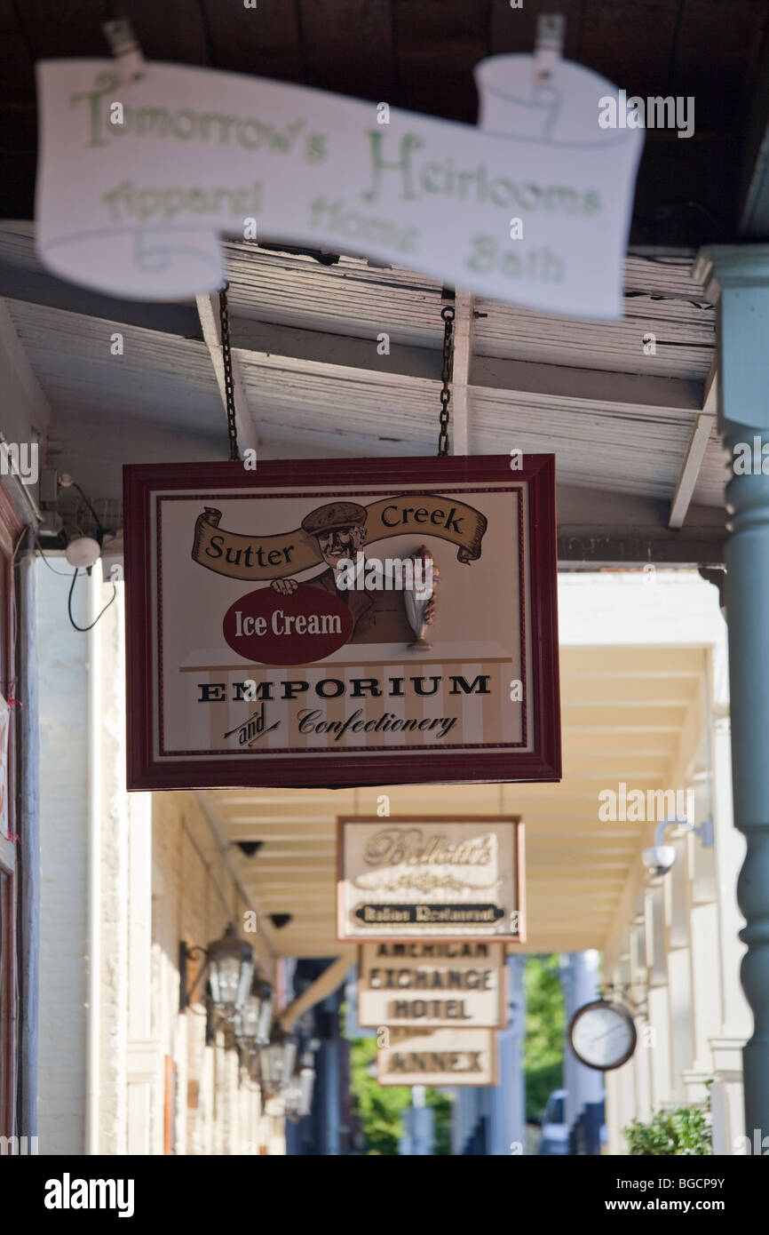Row of signs hanging beneath balcony of old buildings, Main Street, Old ...