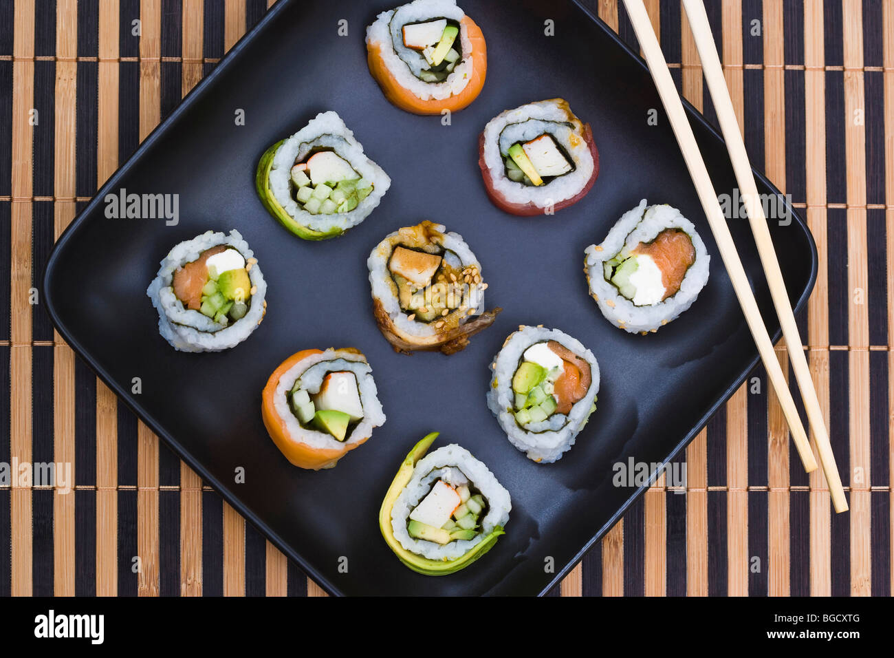 Assorted sushi rolls on black plate, Close up Stock Photo - Alamy