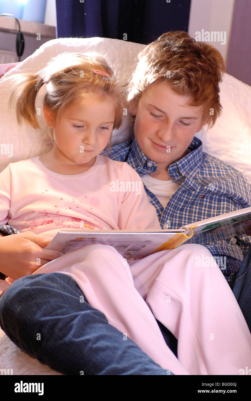 Brother is reading a bedtime story to his sister Stock Photo - Alamy