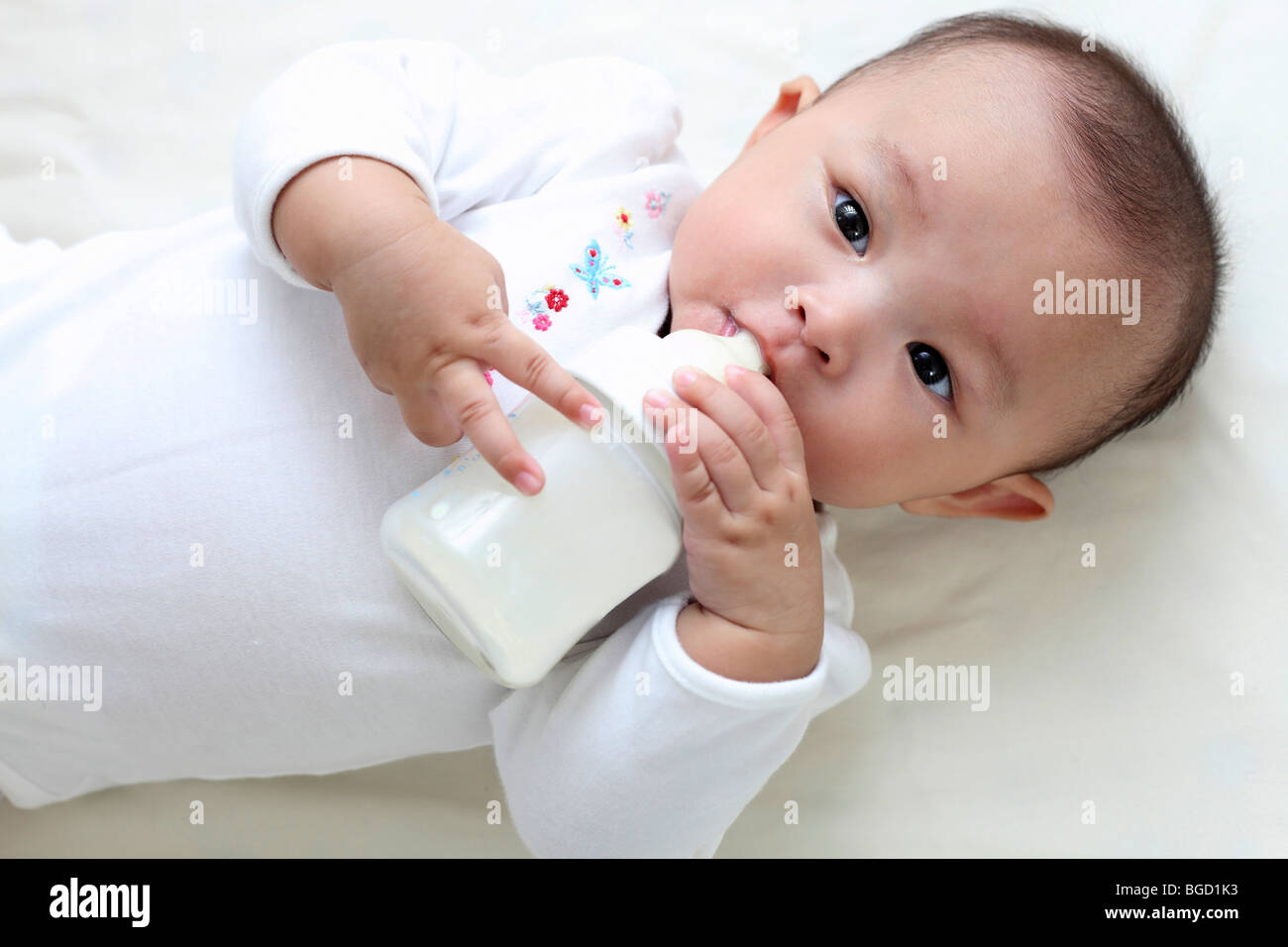 Portrait of baby drinking milk in bottle Stock Photo - Alamy