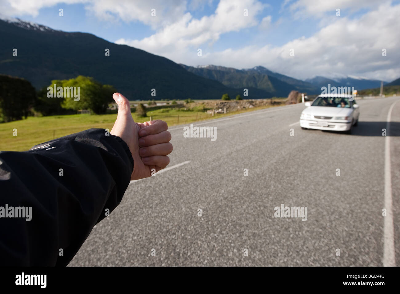 Thumbing a lift hitchhiking in New Zealand Stock Photo - Alamy
