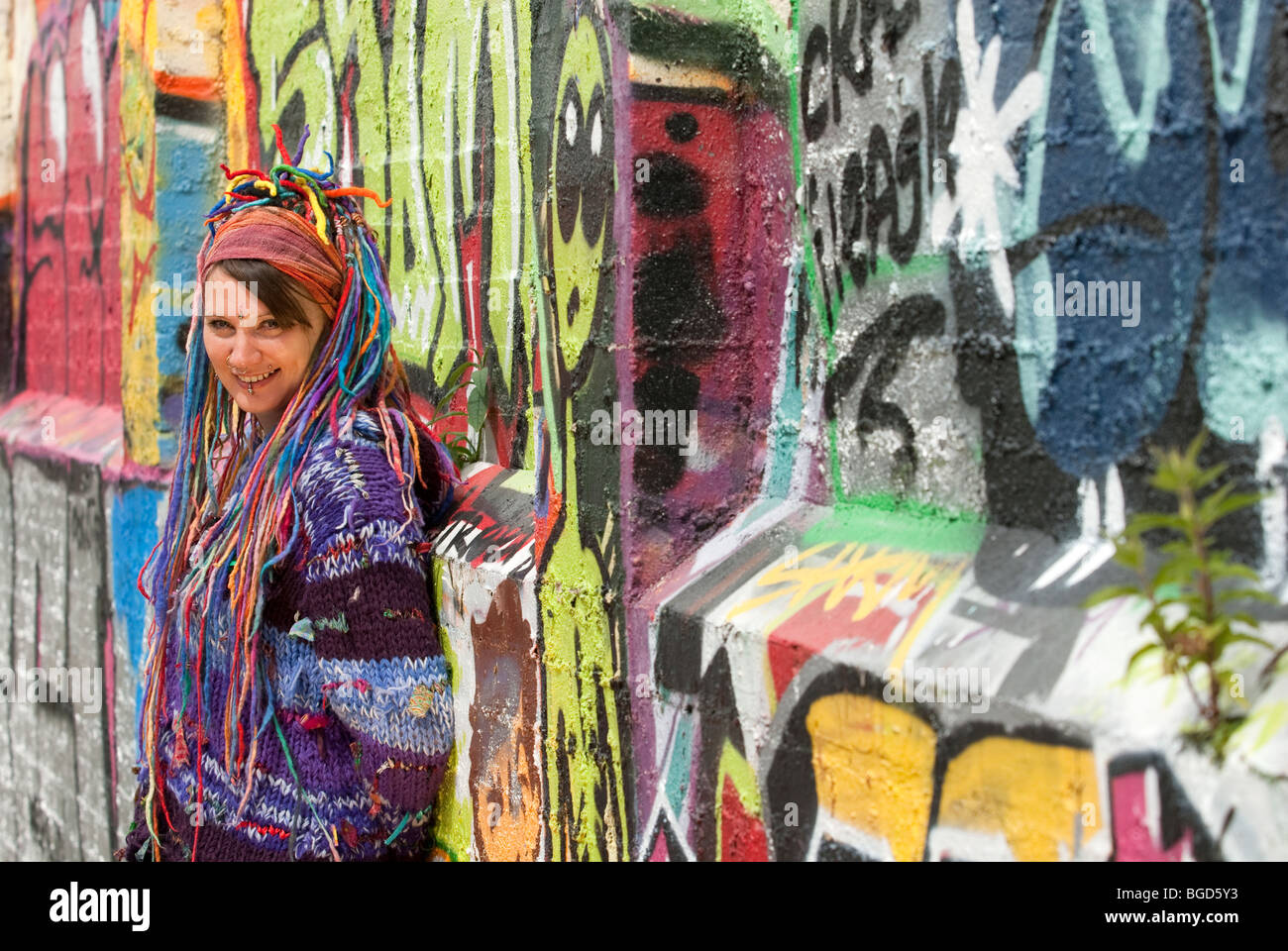 Young female hippy with multi coloured hair against graffiti wall FULLY ...