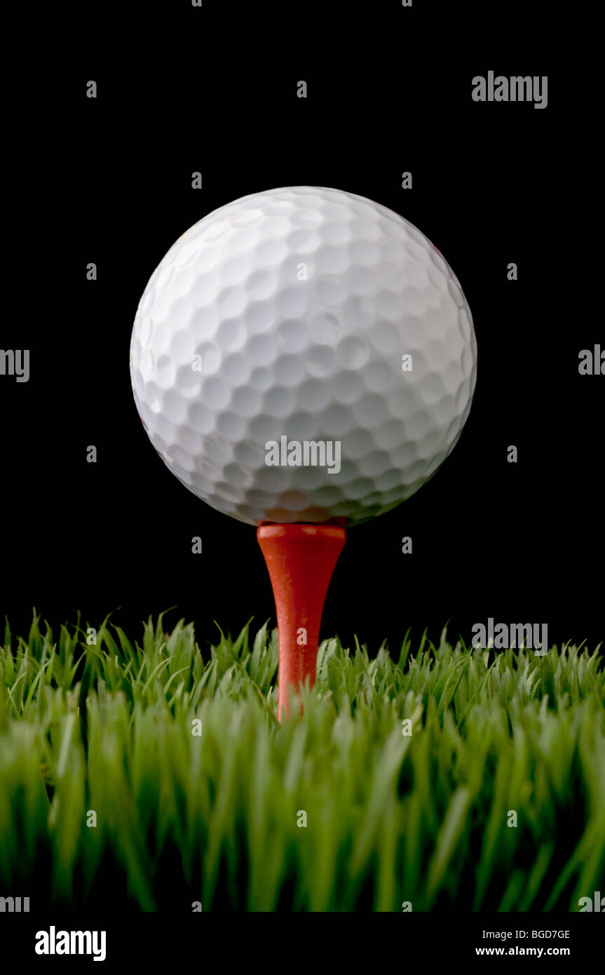 vertical close up of a white golf ball on a tee on black Stock Photo ...