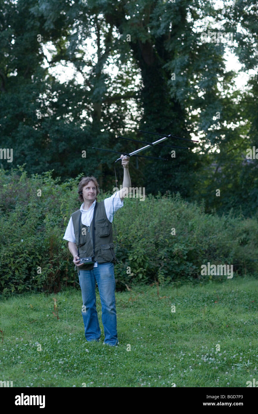 Bat researcher using detection equipment to locate positioning of micro ...