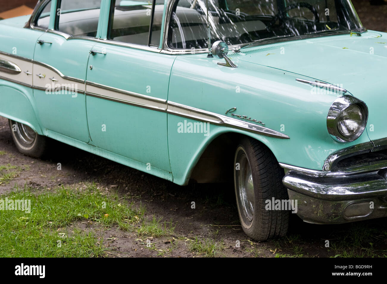 The front and side of a light blue classic Pontiac, focus on the ...