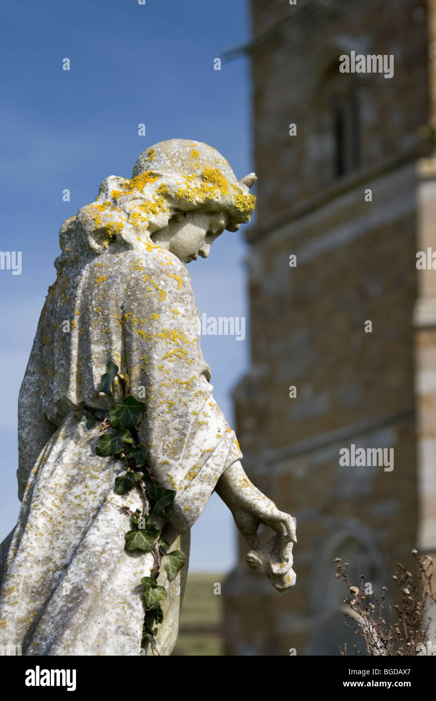 Statue of sad looking girl in churchyard of St Nicholas Church ...