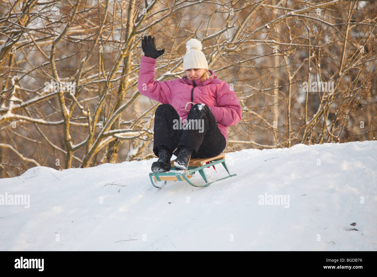 Girl sledging down hill, bright and joyful winter scene Stock Photo - Alamy