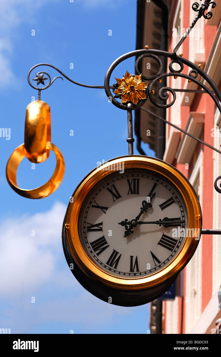 Large clock and two gold wedding rings as a sign outside a jewellery ...