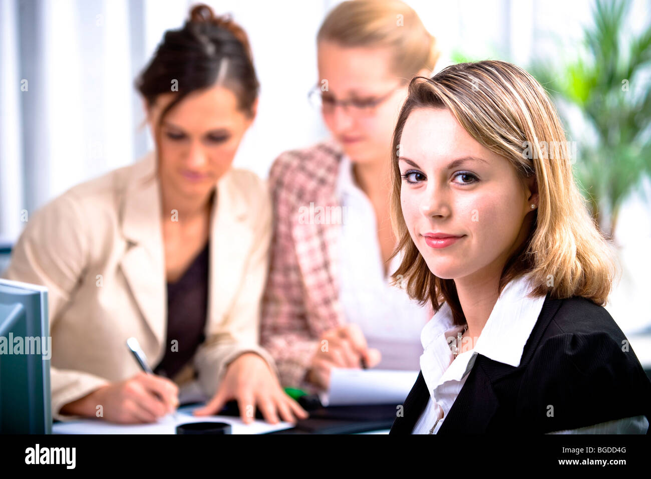 Young woman with her colleagues in an office Stock Photo - Alamy