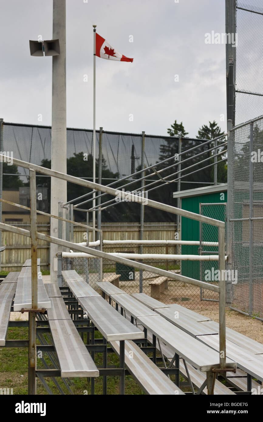 Empty benches at a minor league baseball stadium, with a Canadian flag ...
