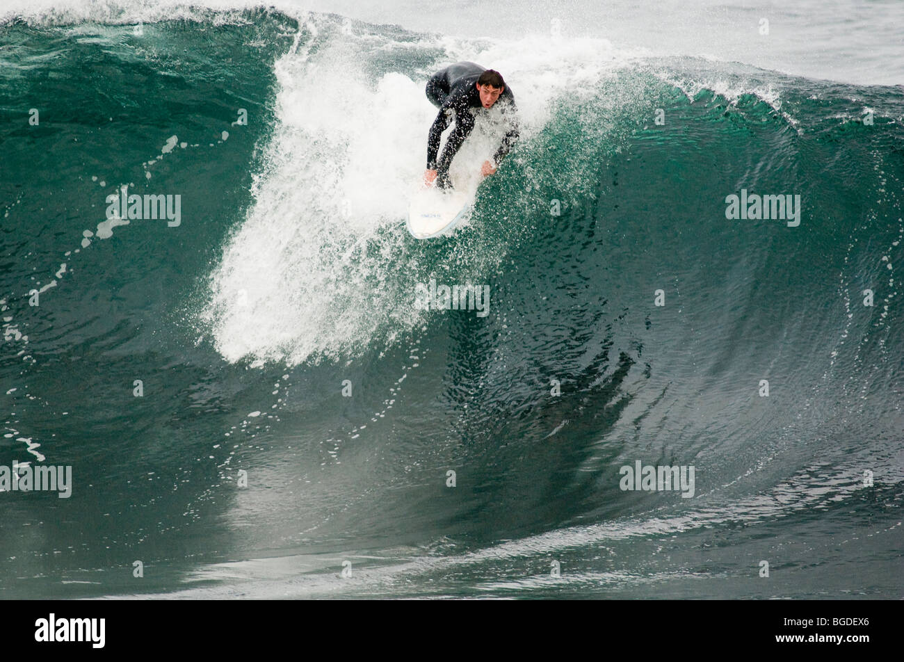A surfer at the top of a big wave surfing in the United Kingdom at a ...