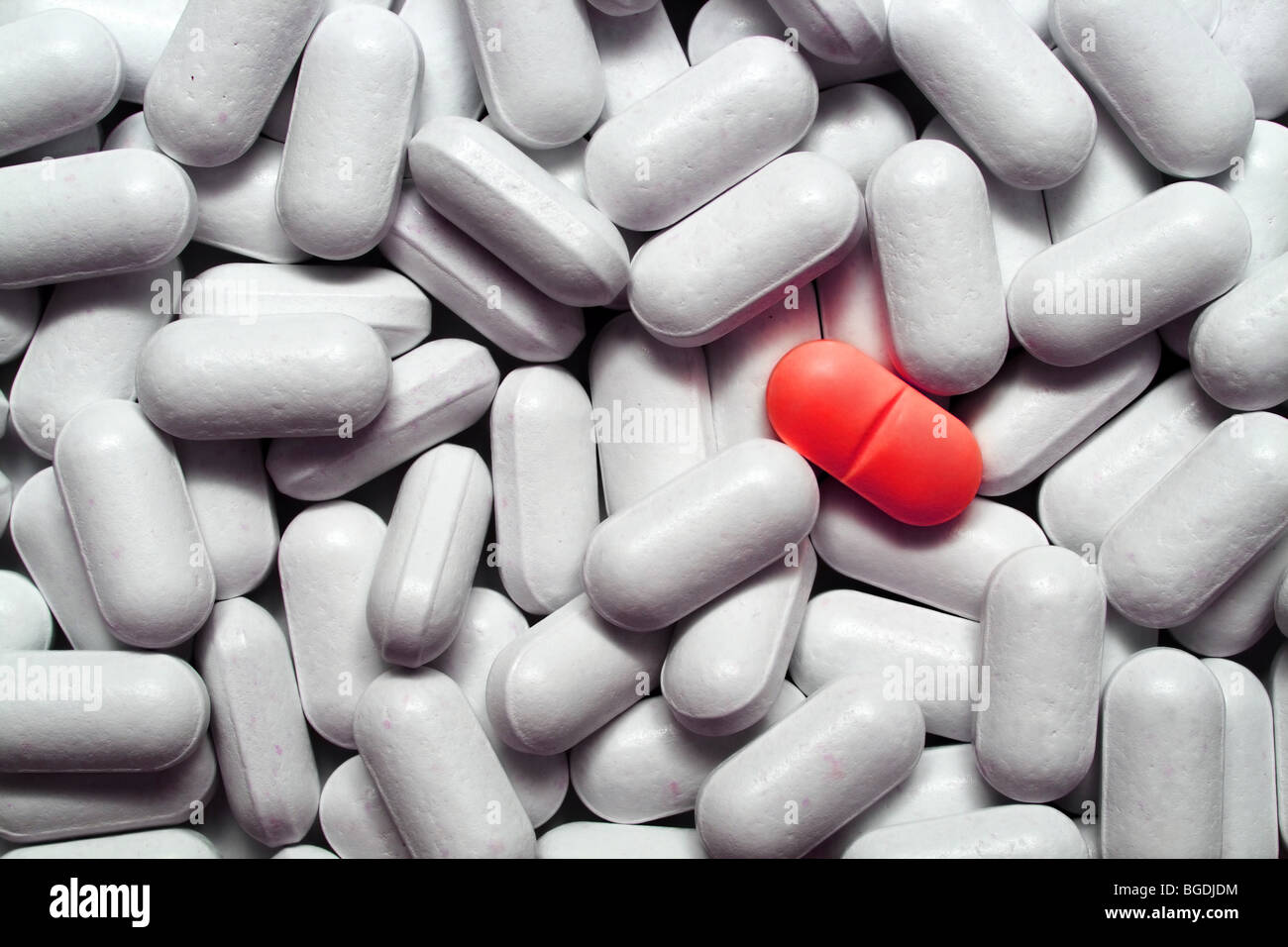 different - one red pill among grey pills Stock Photo - Alamy