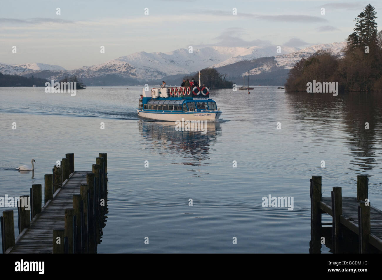 Lake Windermere in Winter with passenger ferry, passengers and snowy ...