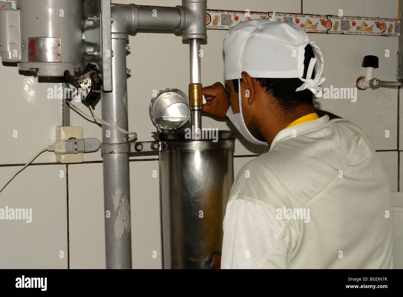 A man processing acai berries to make traditional "wine" or juice using ...