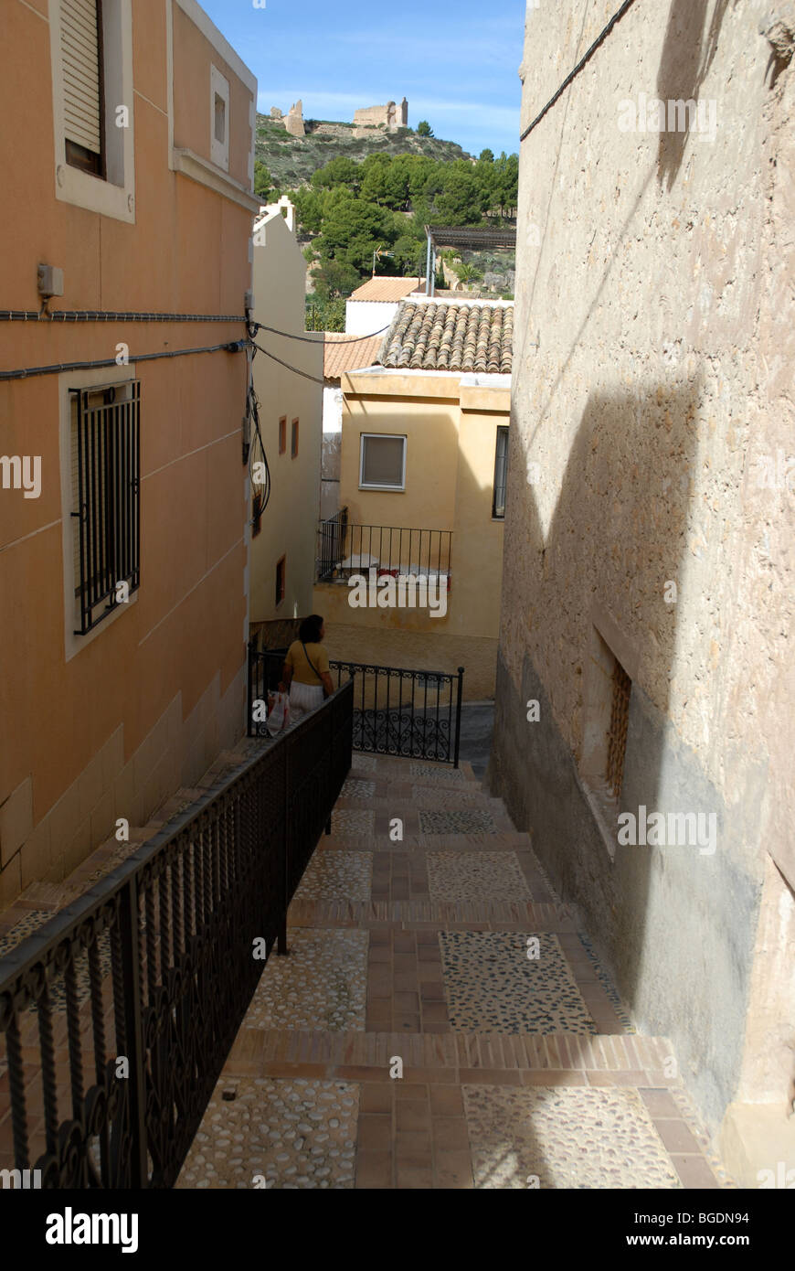 woman walking down steps of narrow street in the mountain village of ...