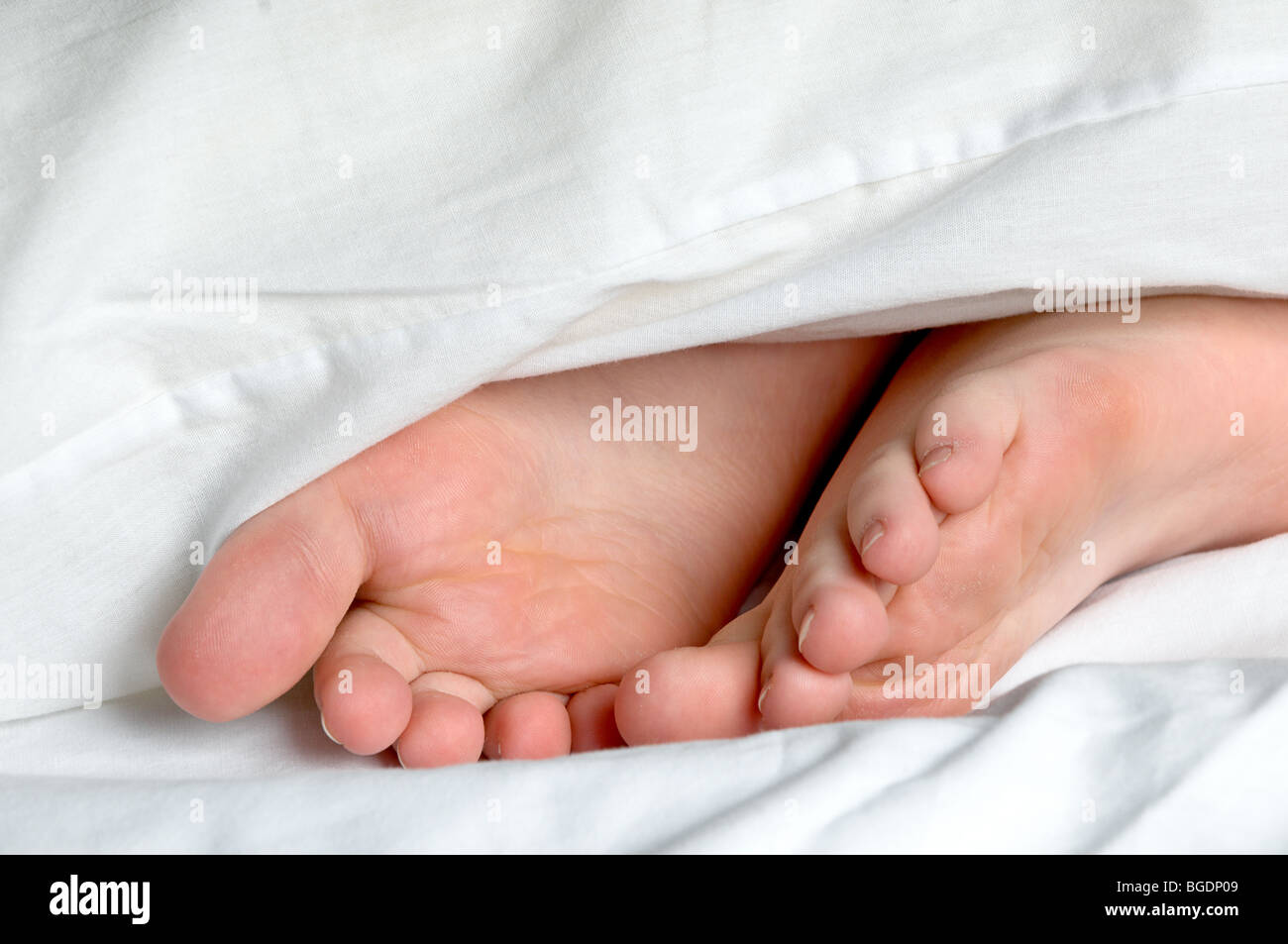 a sleeping child's feet in bedding Stock Photo - Alamy
