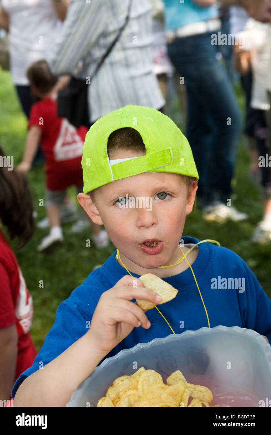 Child eating junk food at a party outdoor Stock Photo - Alamy