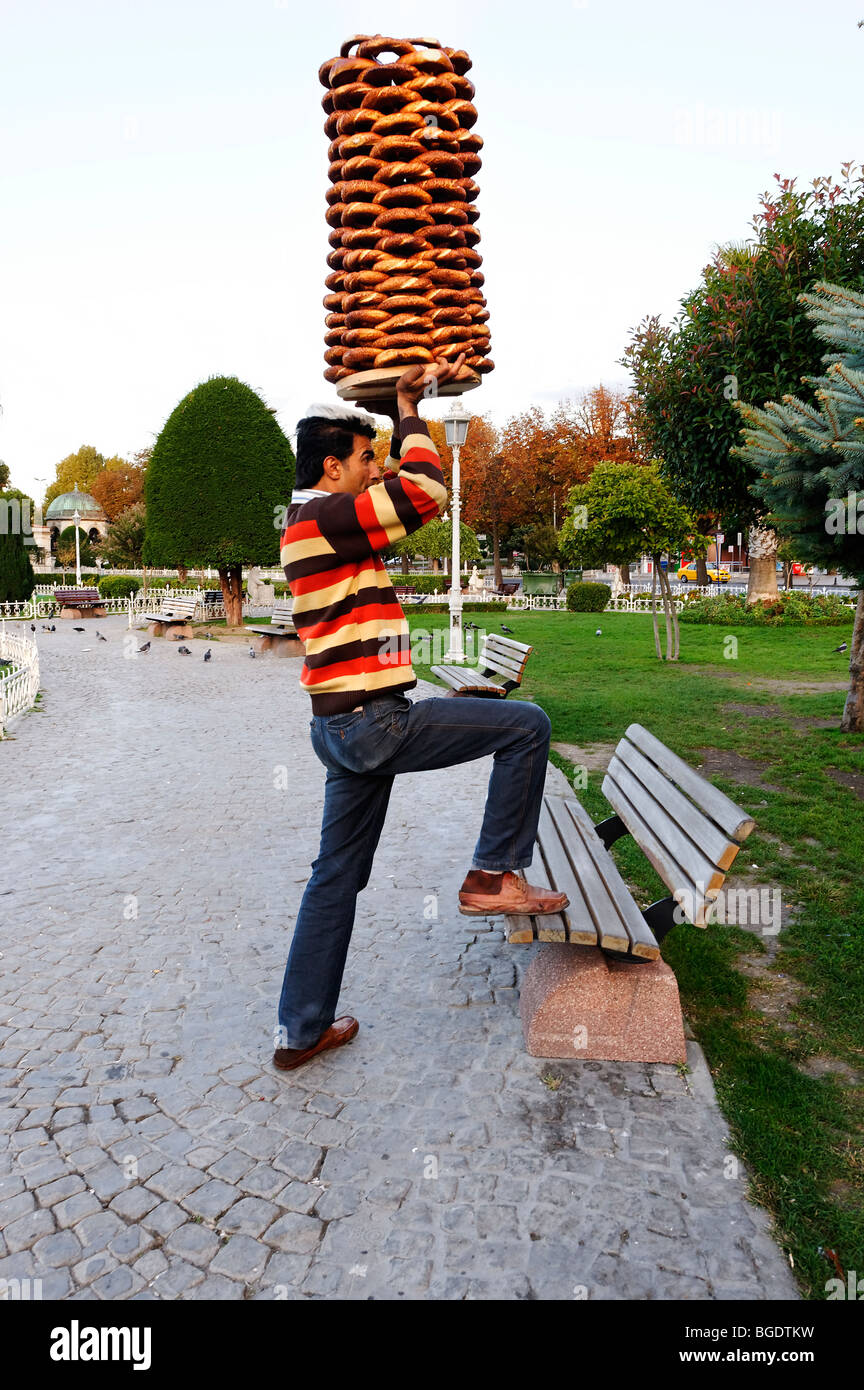 Turkish baker lifting a tray of bread rolls -Simit loaves on to his ...