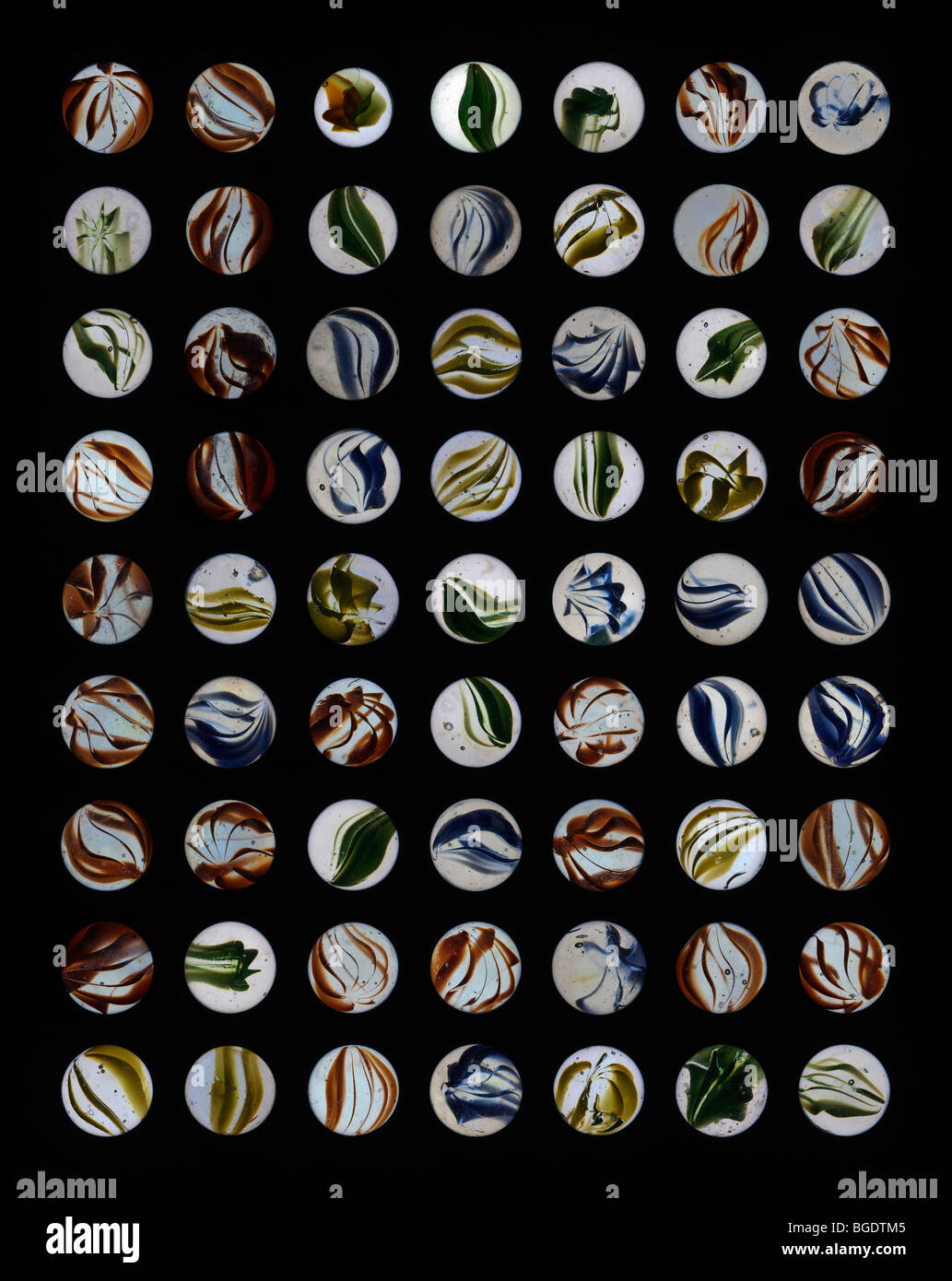 lots of marbles in a line black background Stock Photo - Alamy