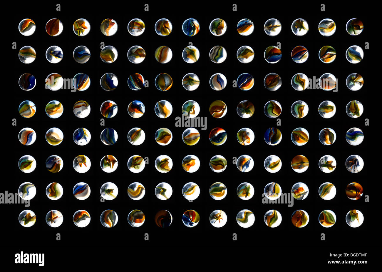lots of marbles in a line black background Stock Photo - Alamy