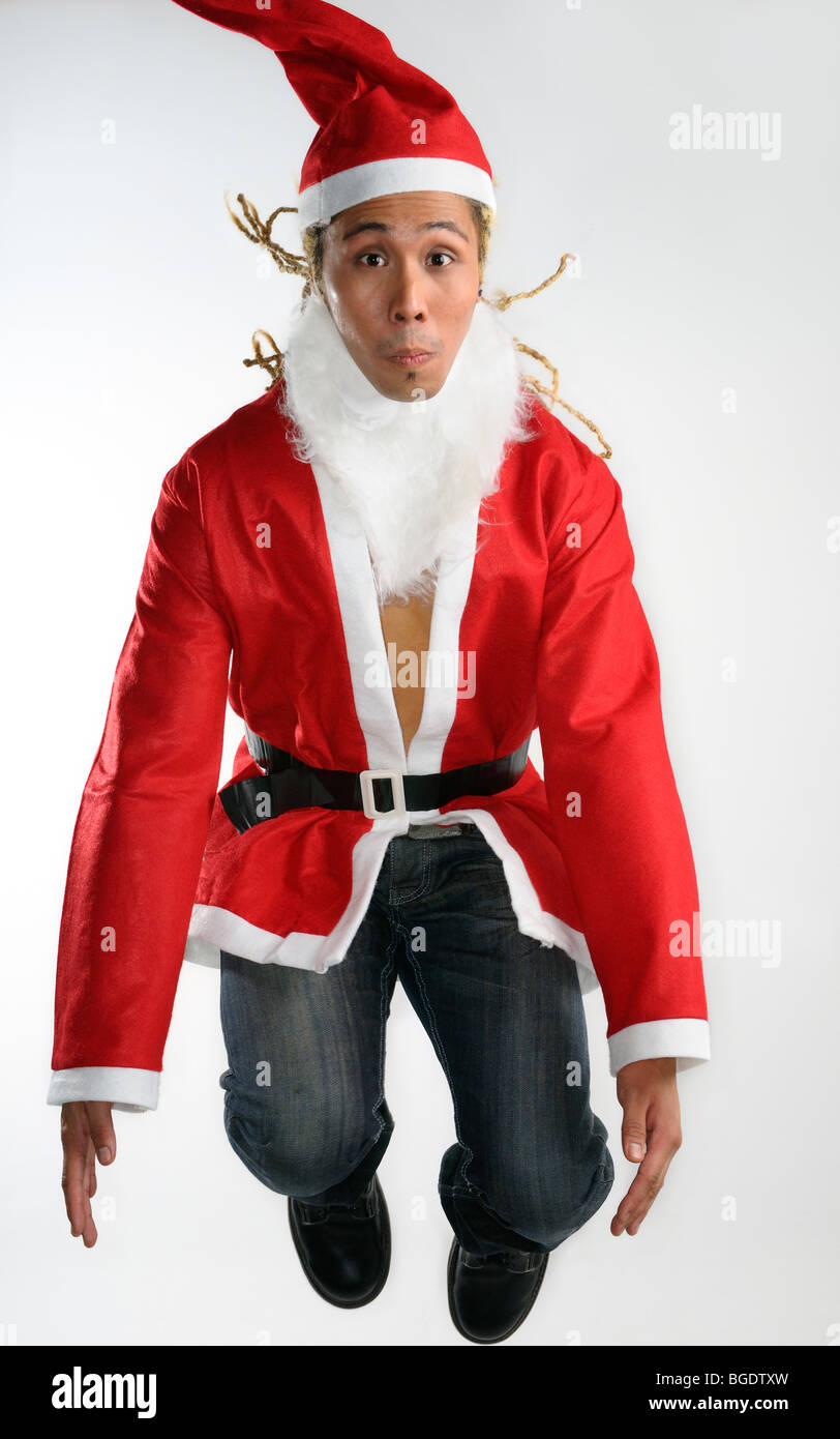 Man with dreadlocks dressed in Santa Claus costume jumping in the air ...