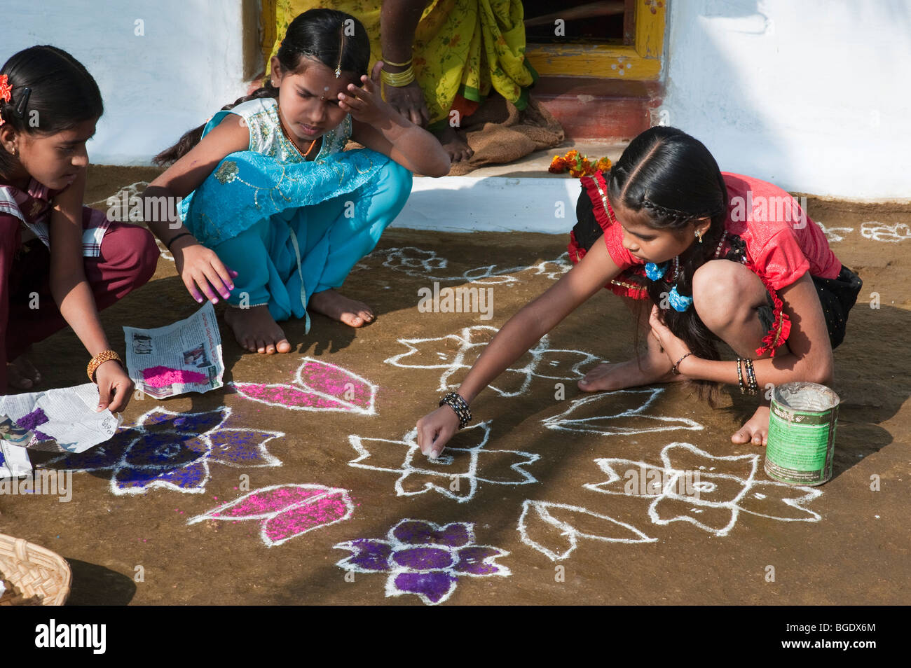 Rural indian village girls making a rangoli design in a rural indian ...