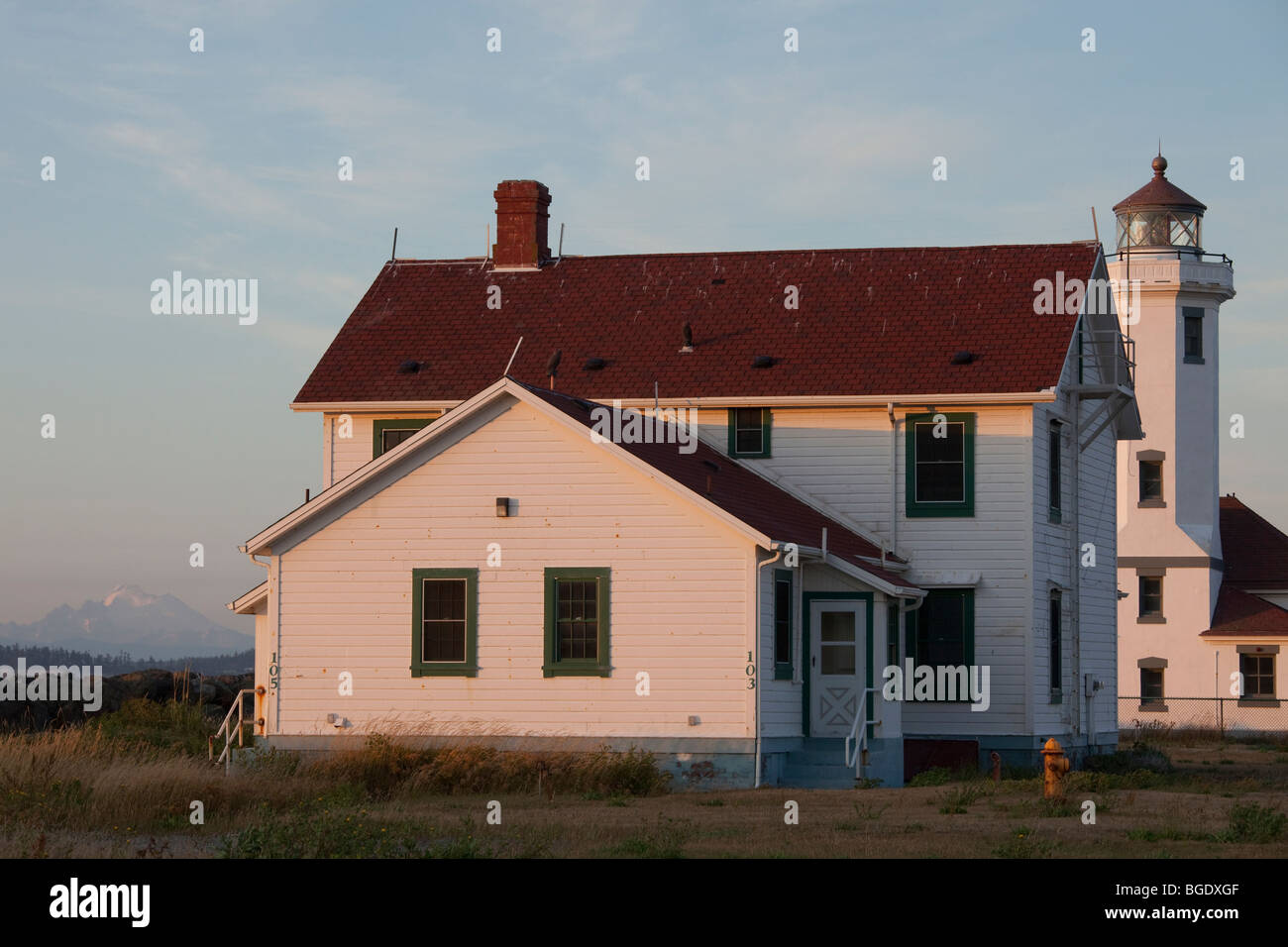 Point Wilson Lighthouse in warm evening light, with mountain visible in ...