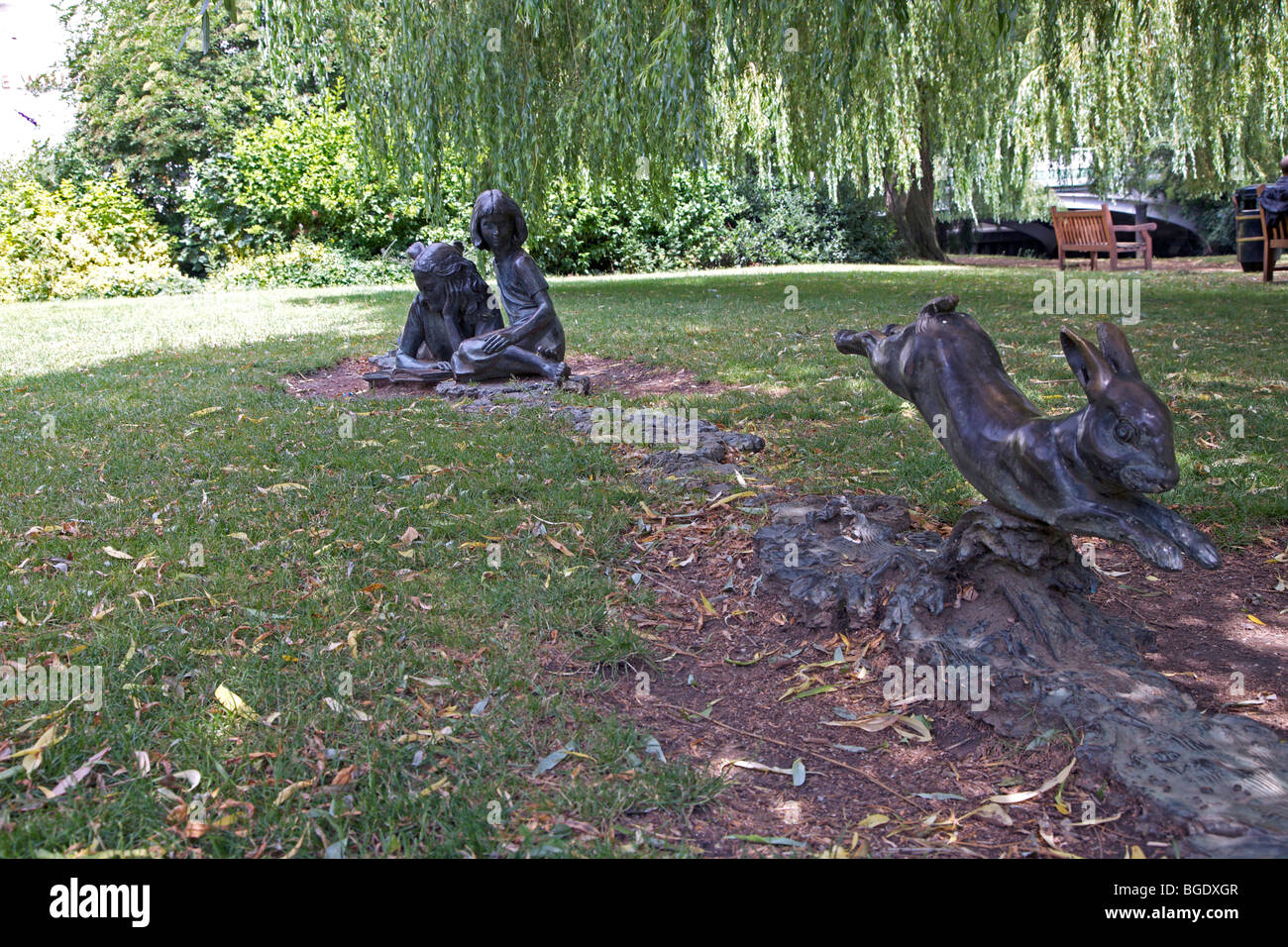 Bronze statue of Alice in Wonderland watching the White Rabbit run for ...