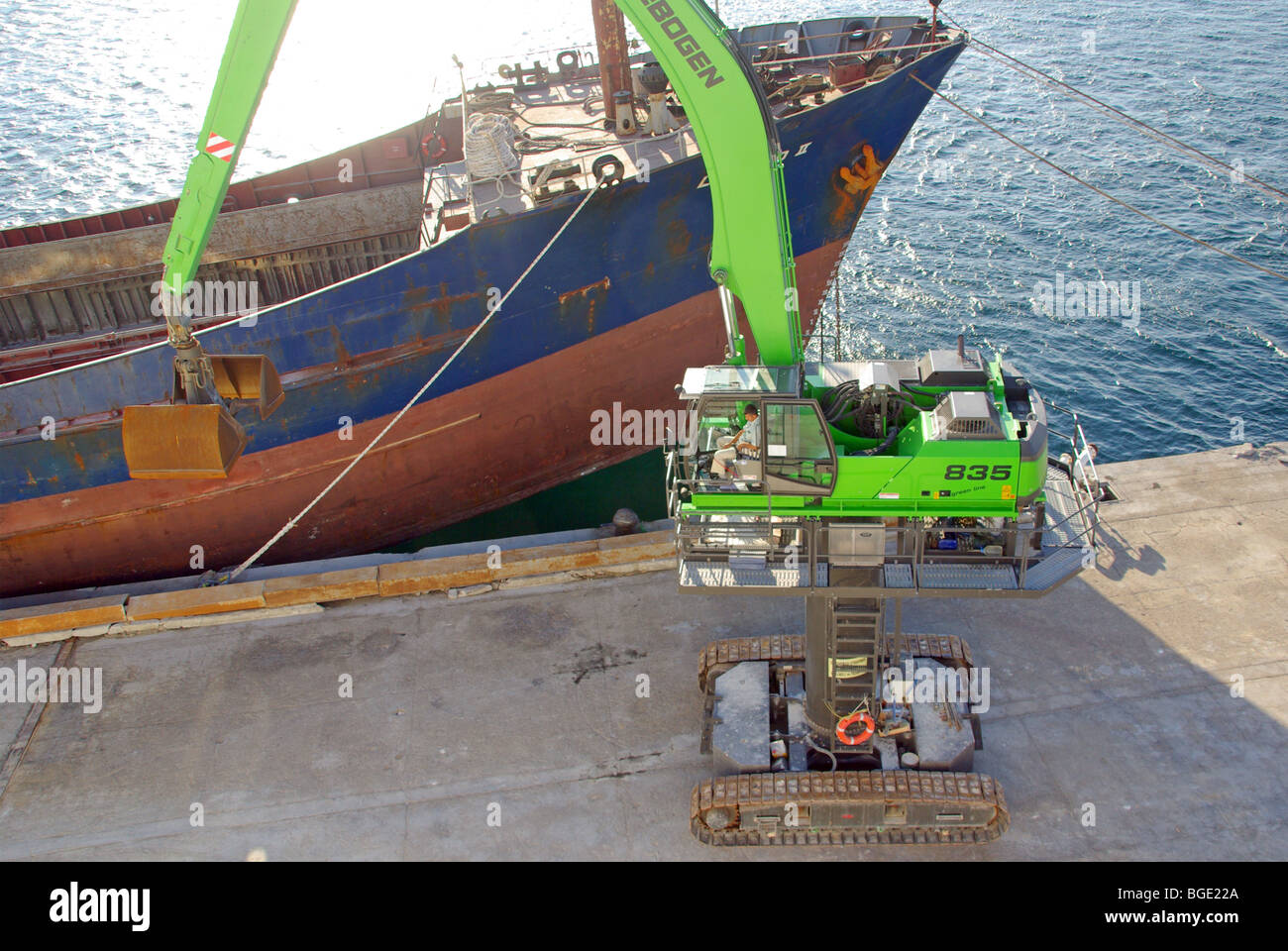 Dockyard mobile crane with caterpillar tracks and driver alongside ...