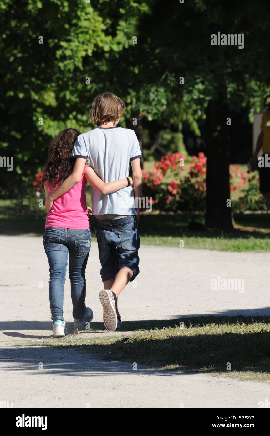 Boy girl teenagers courting couple arm in arm rear view Castle park ...
