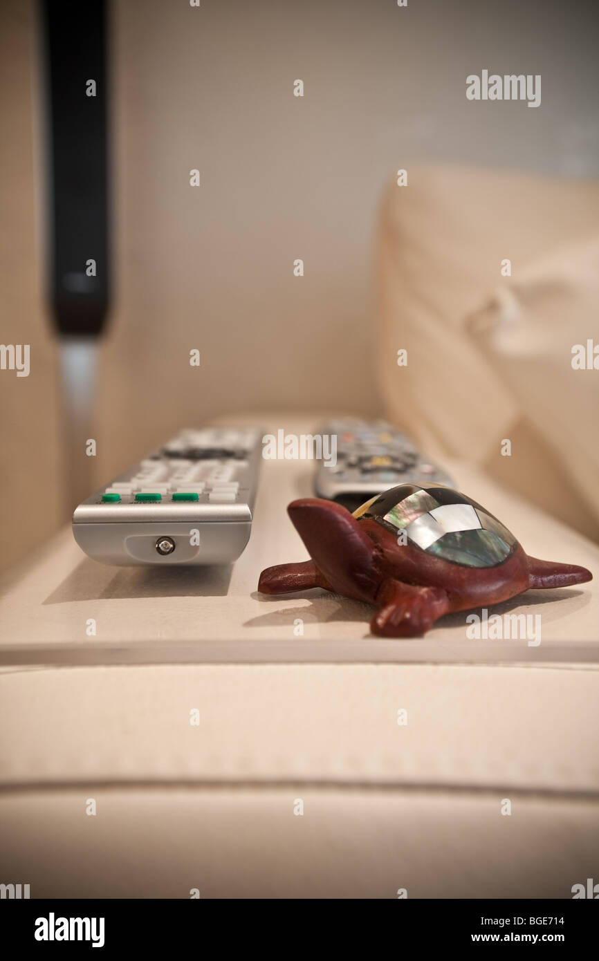 Wooden turtle sculpture and TV remote Stock Photo - Alamy