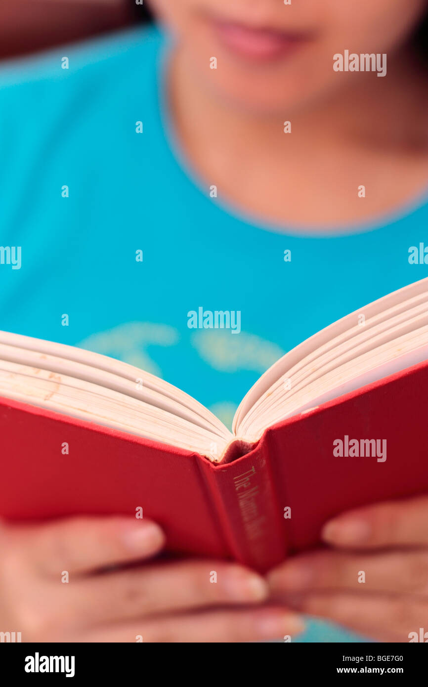 Woman leaning against headboard reading Stock Photo - Alamy