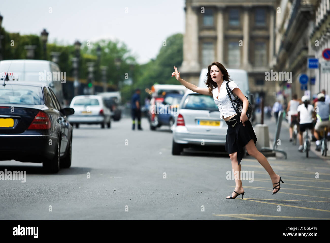beautiful charming woman hailing a taxi cab in the street of paris ...