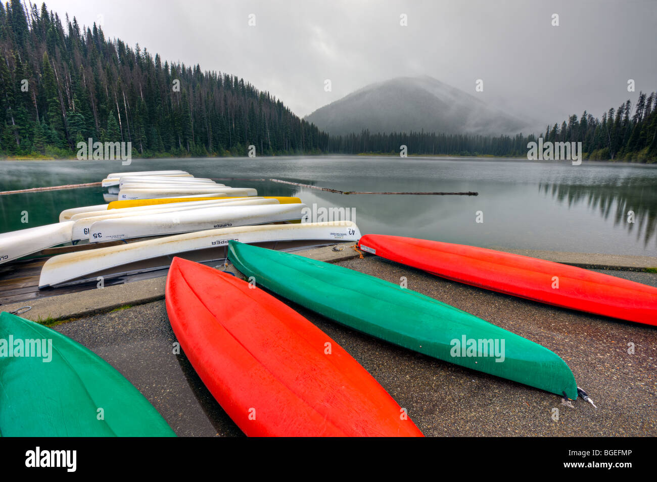 Red and green canoes hauled out on the shores of Lightning Lake in ...