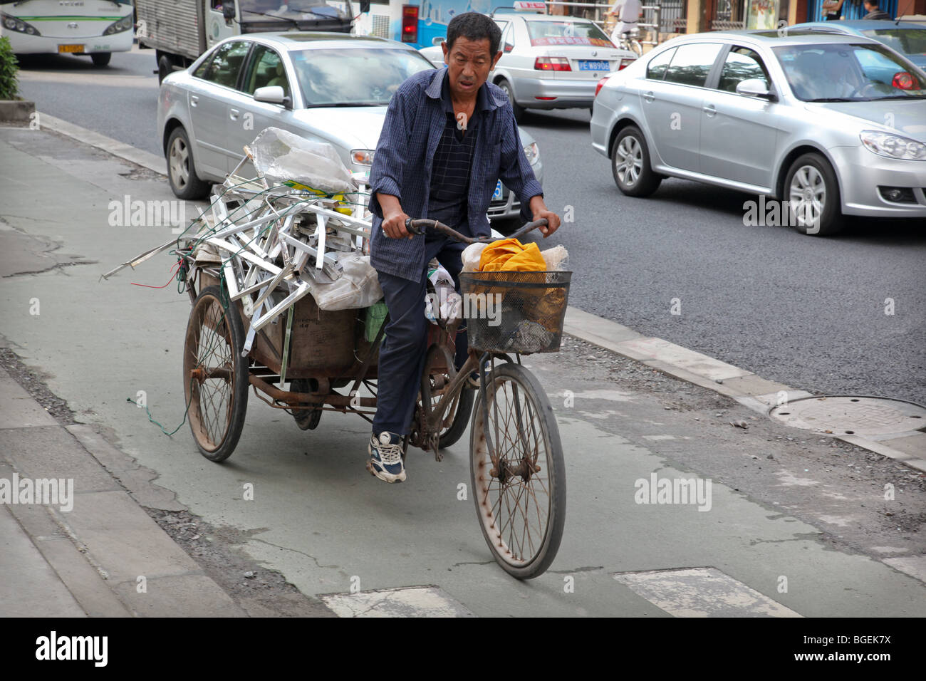 Man riding three wheeler carrying garbage in Shanghai Stock Photo - Alamy