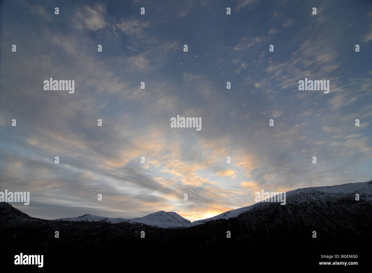 The sun setting behind snow covered mountains in Norway, winter Stock ...