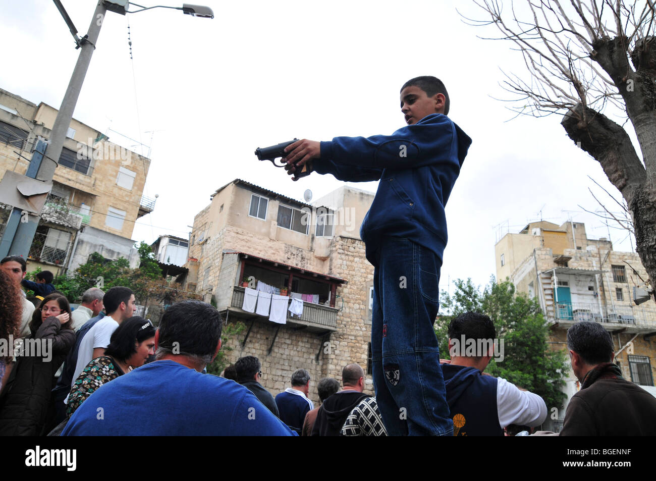 Young Arab Boy points a hand gun at the crowd Stock Photo - Alamy