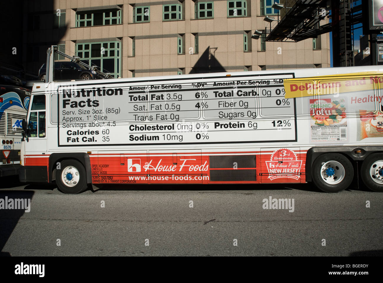 A commuter bus parked in New York is decorated with a full wrap ...