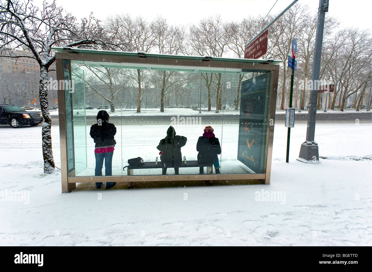 People wait for the morning bus protected by the glass enclosed bus ...