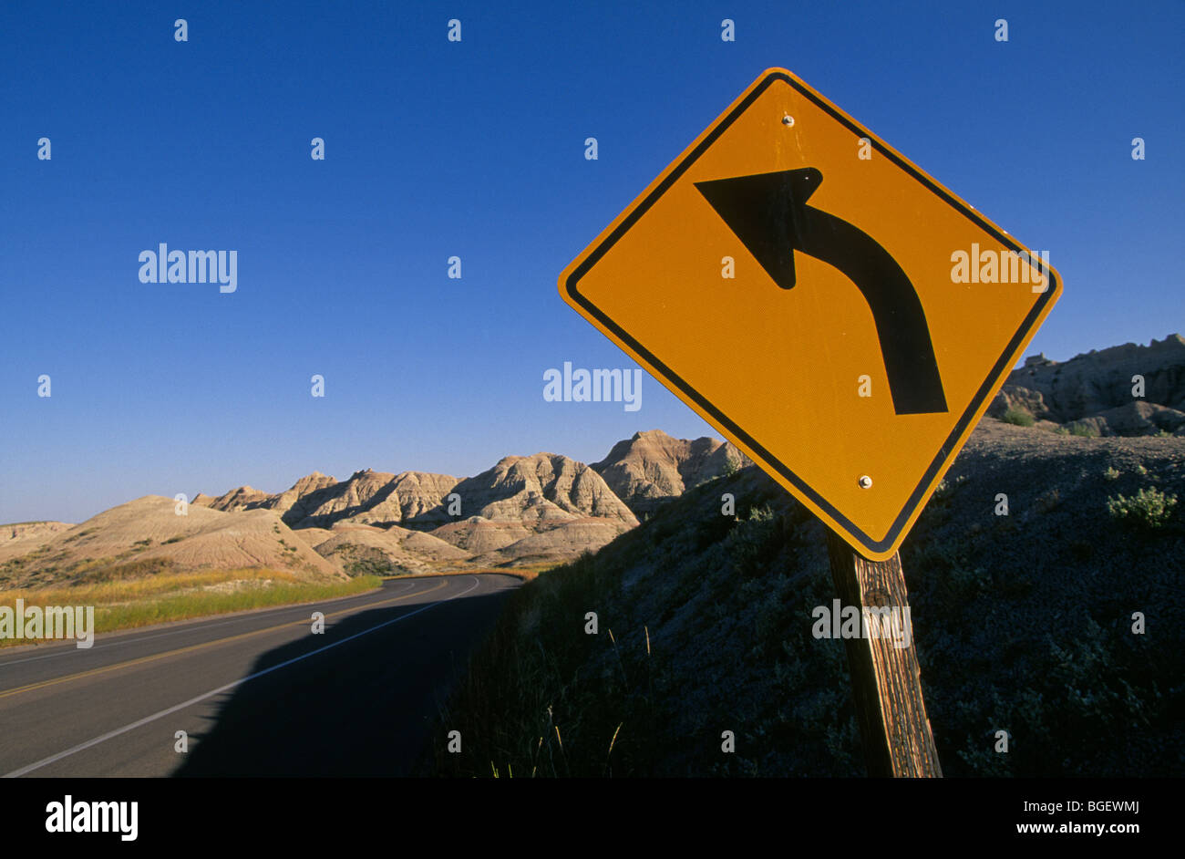 A curvy highway sign on the main access road in Badlands National Park ...