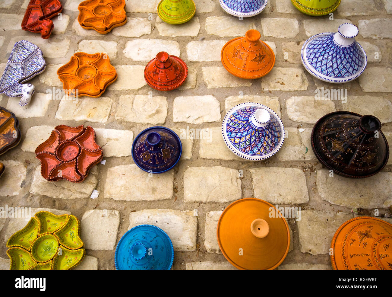 Brightly coloured Tunisian ceramic dishes and tagines displayed on ...
